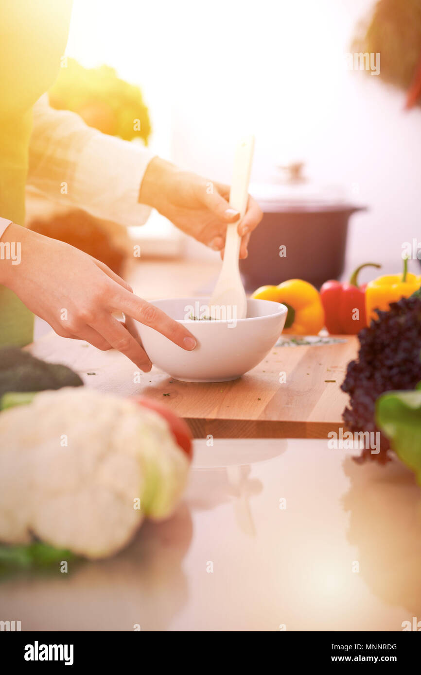 Close Up of human hands cooking vegetable salad in kitchen on the glass ...