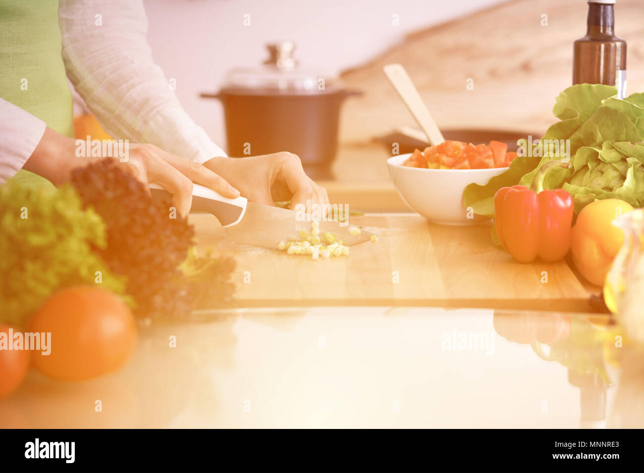 Close Up of human hands cooking vegetable salad in kitchen on the glass ...