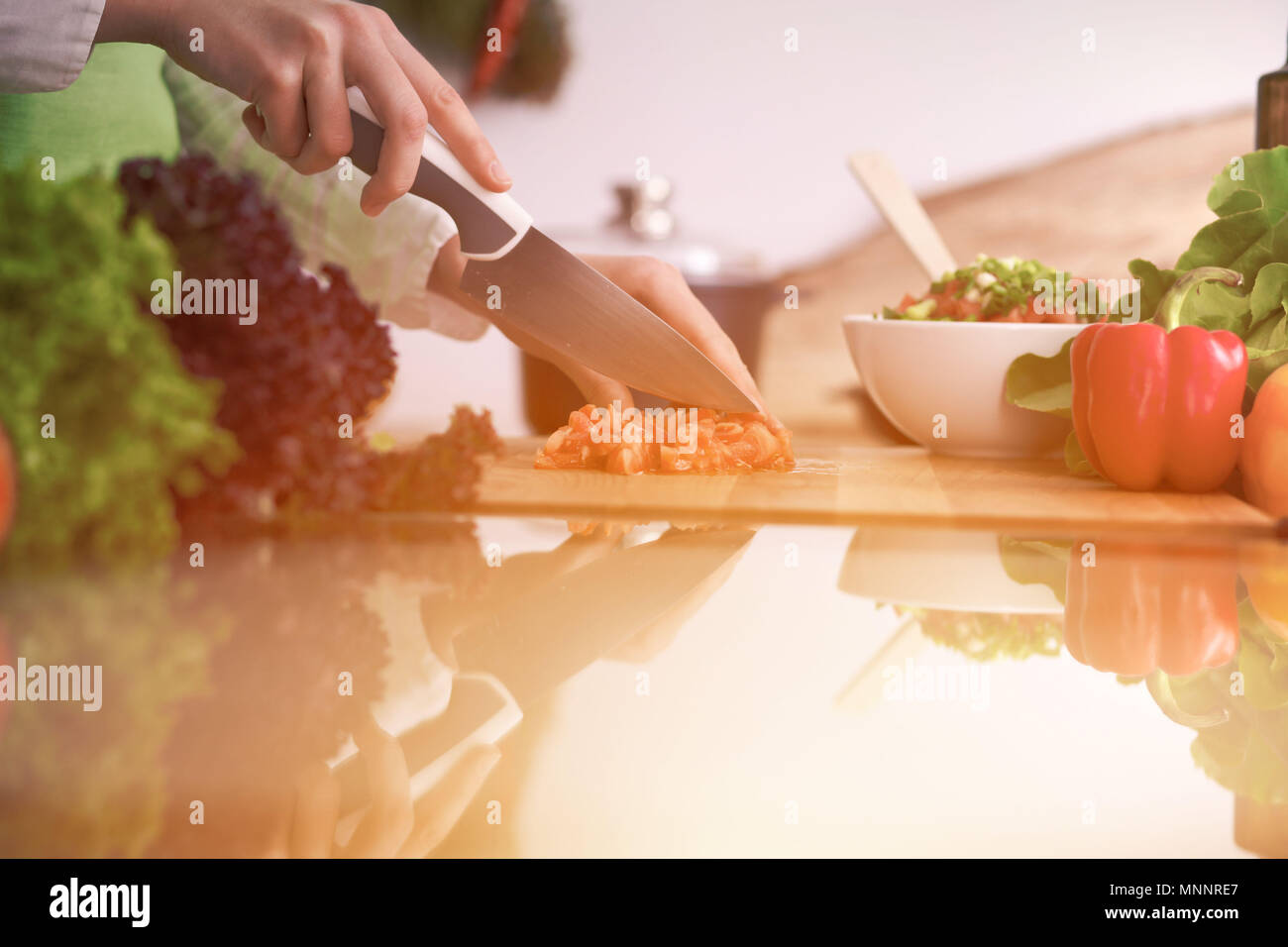 Close Up of human hands cooking vegetable salad in kitchen on the glass ...
