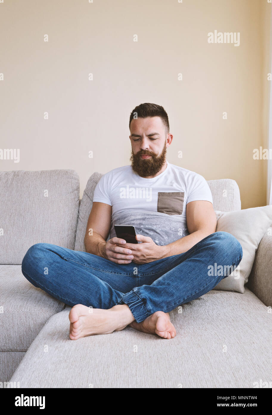 Close Up Portrait Of Adult Caucasian Bearded Man Sitting On Beige Sofa
