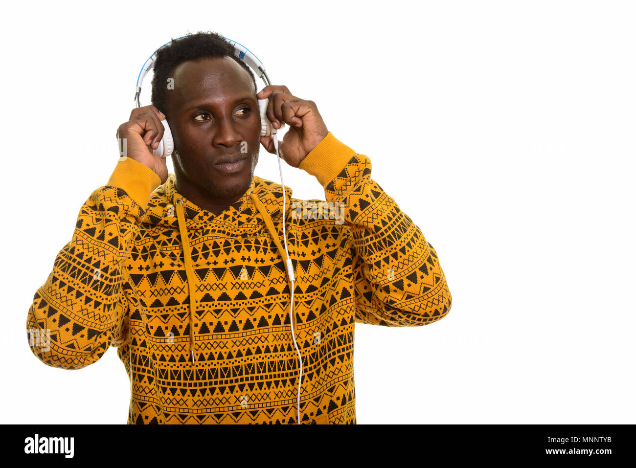 Young black African man holding headphones and listening to musi Stock ...