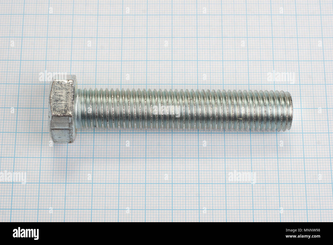 Screw on graph paper background Stock Photo - Alamy