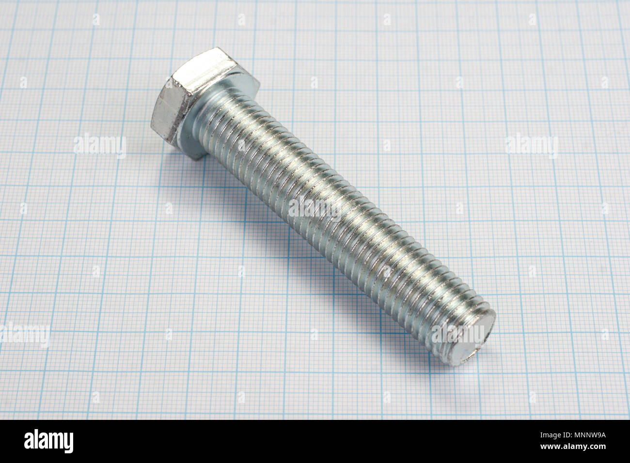 Screw on graph paper background Stock Photo - Alamy