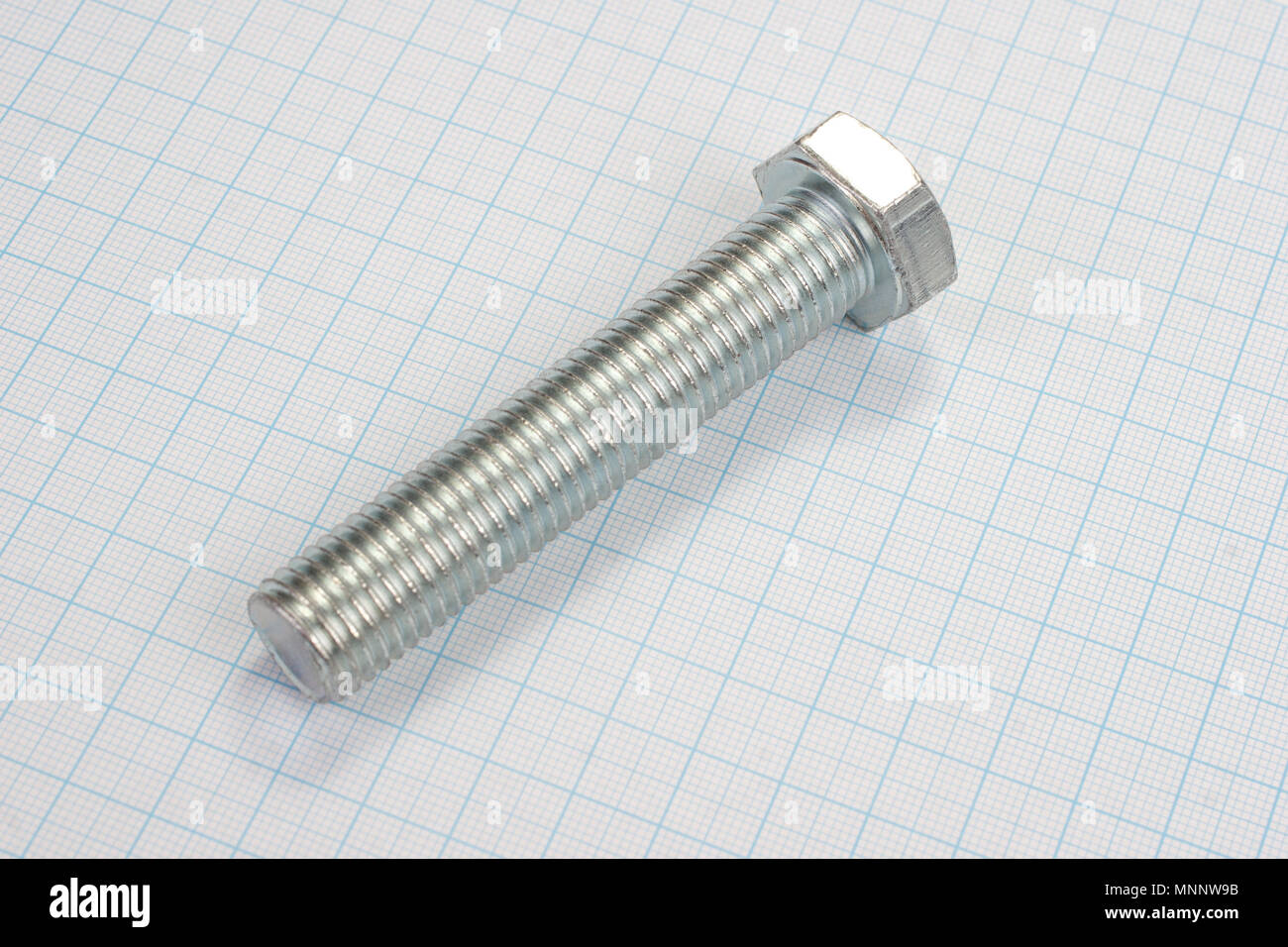 Screw on graph paper background Stock Photo - Alamy