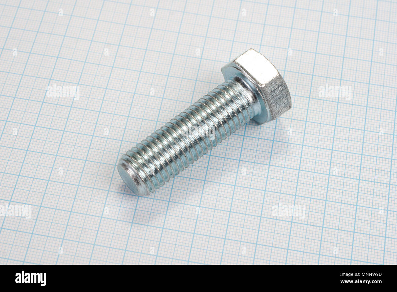 Screw on graph paper background Stock Photo - Alamy