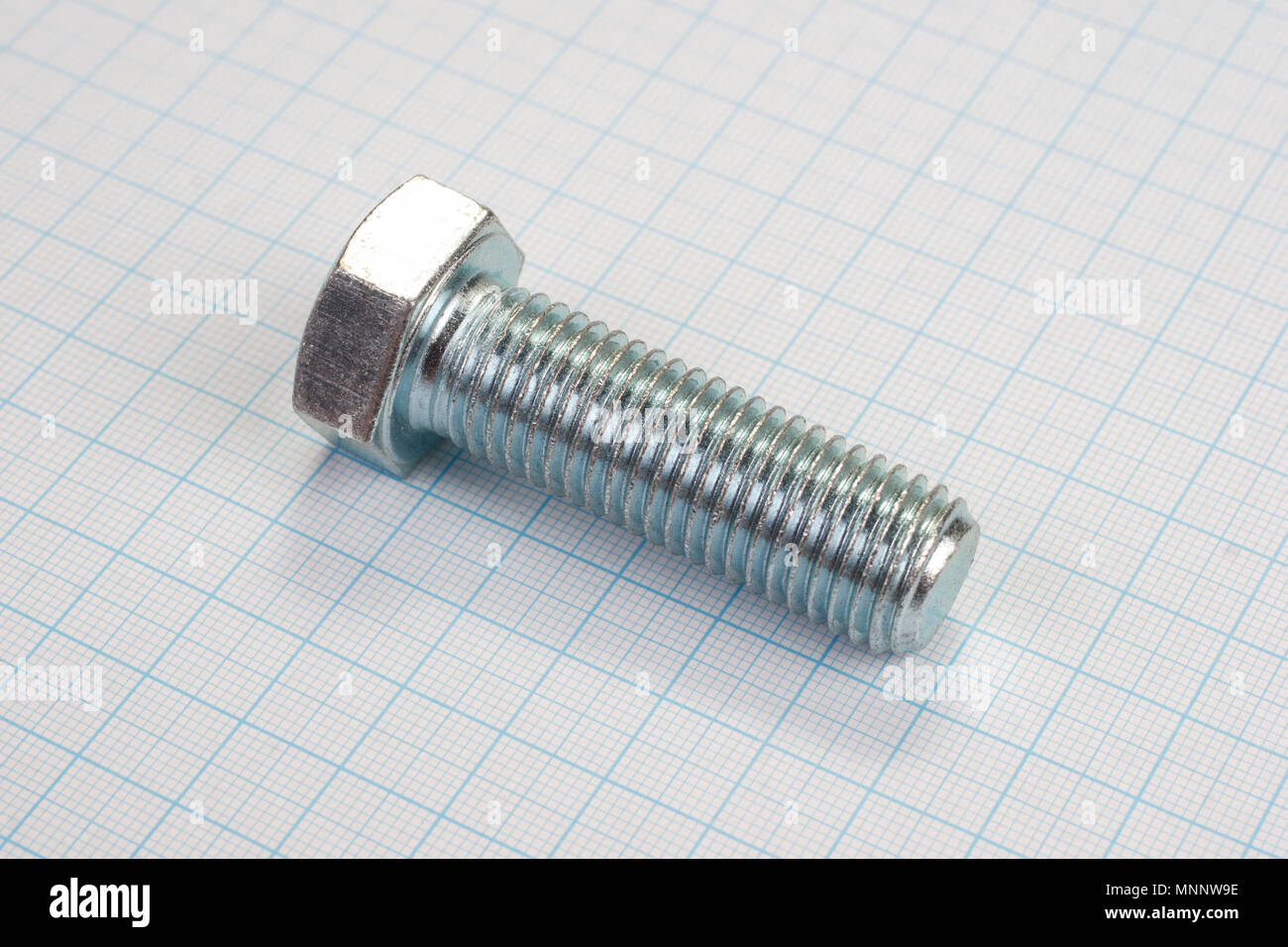 Screw on graph paper background Stock Photo - Alamy