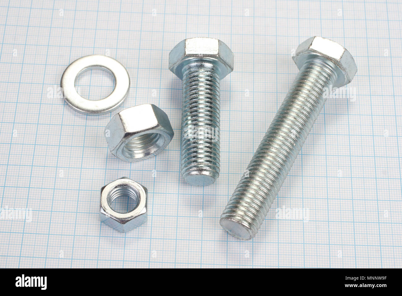 Screw and Nuts on graph paper background Stock Photo - Alamy