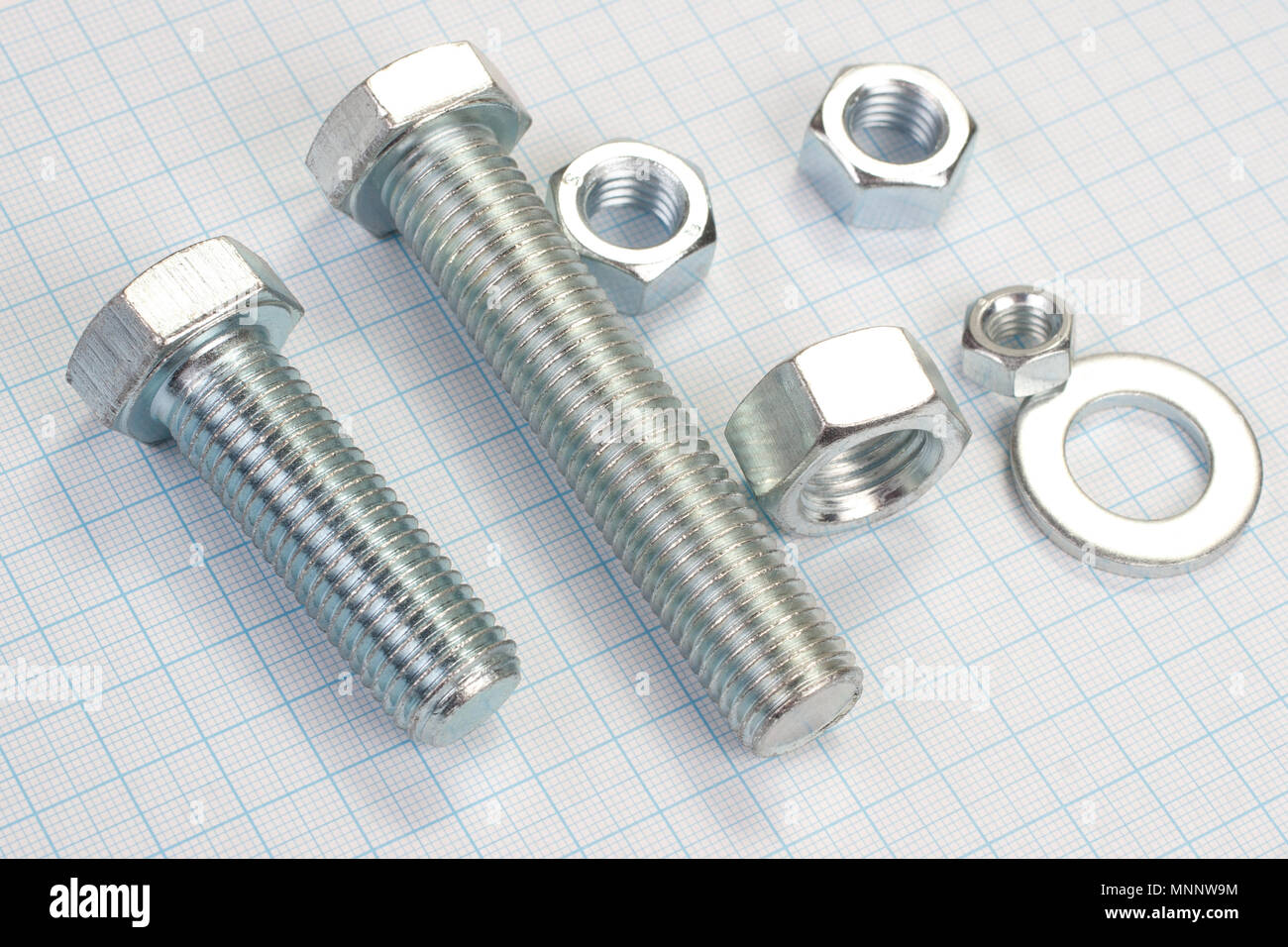 Screw and Nuts on graph paper background Stock Photo - Alamy