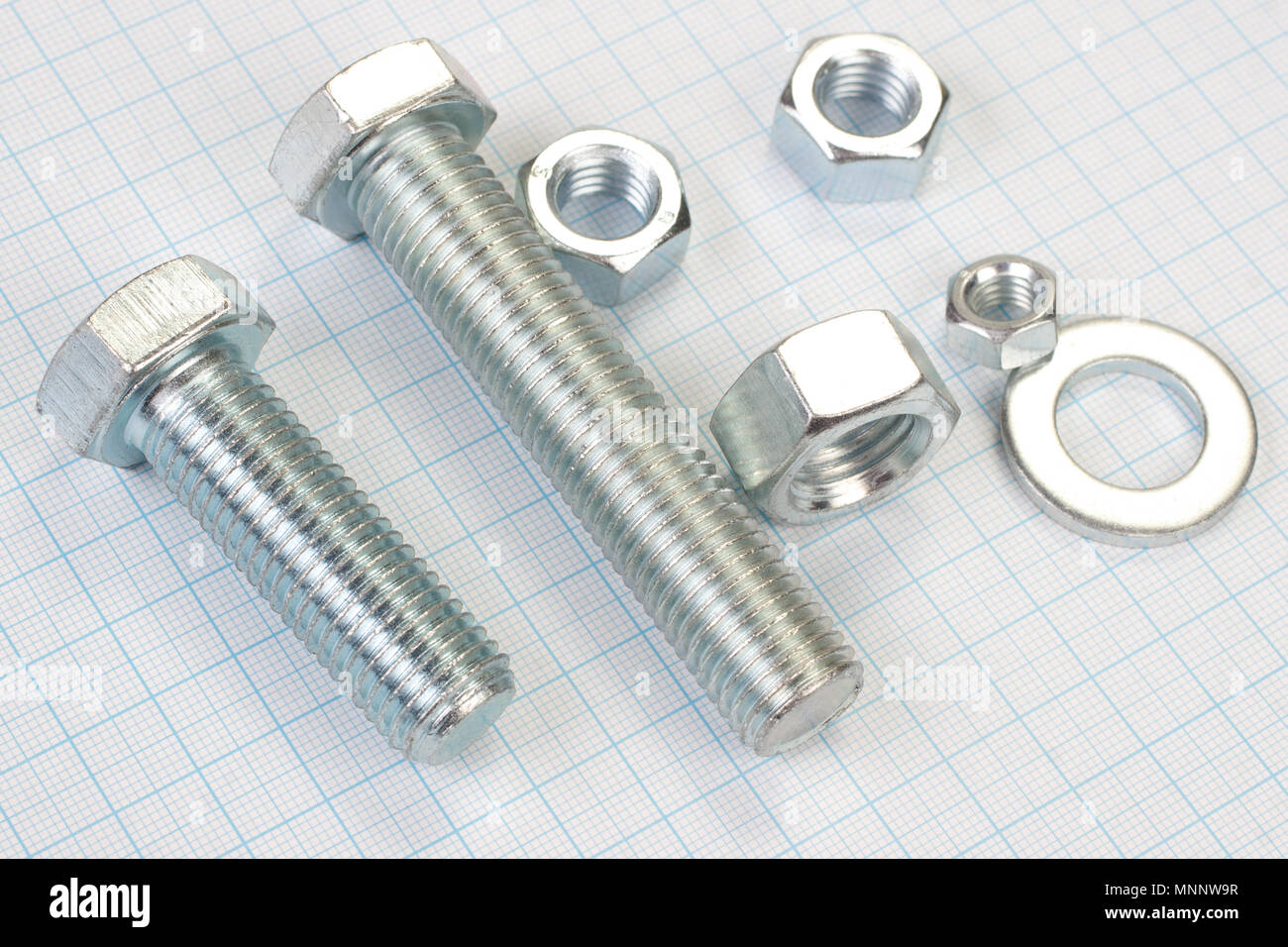 Screw and Nuts on graph paper background Stock Photo - Alamy