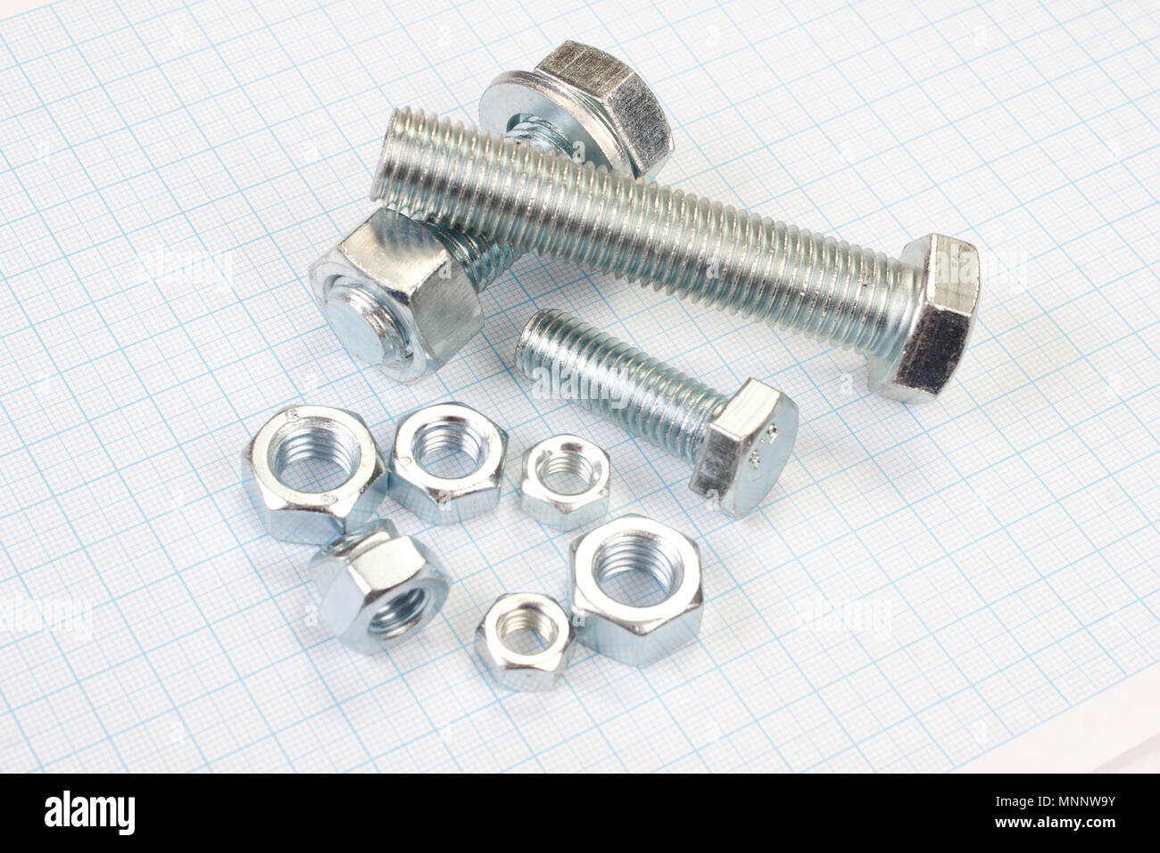 Screw and Nuts on graph paper background Stock Photo - Alamy