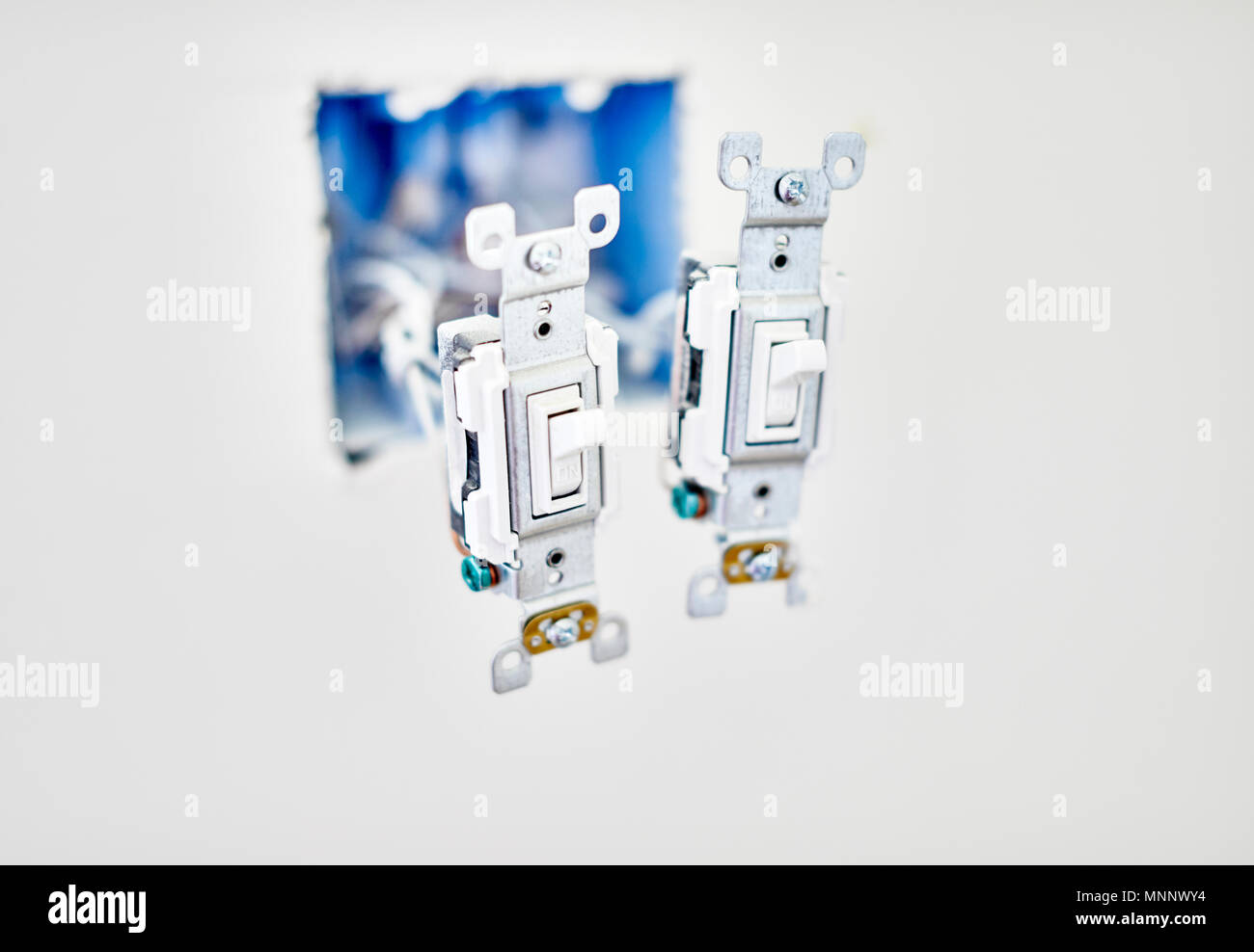 Two new light switches hanging from wires while being installed in new ...