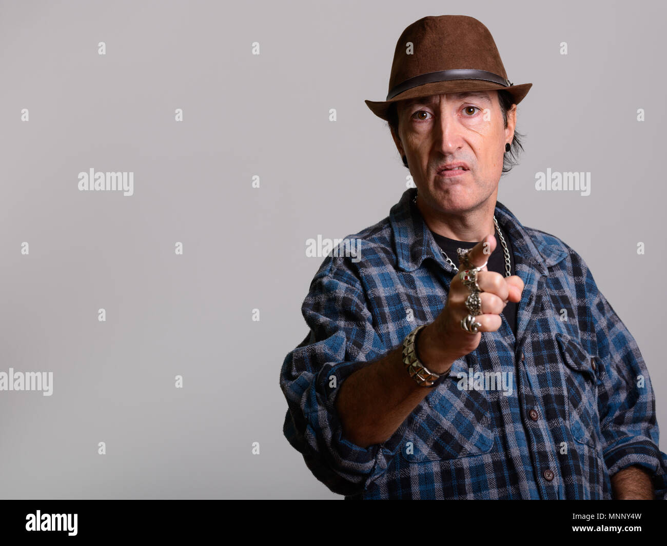 Studio shot of angry mature gangster man pointing finger at came Stock ...