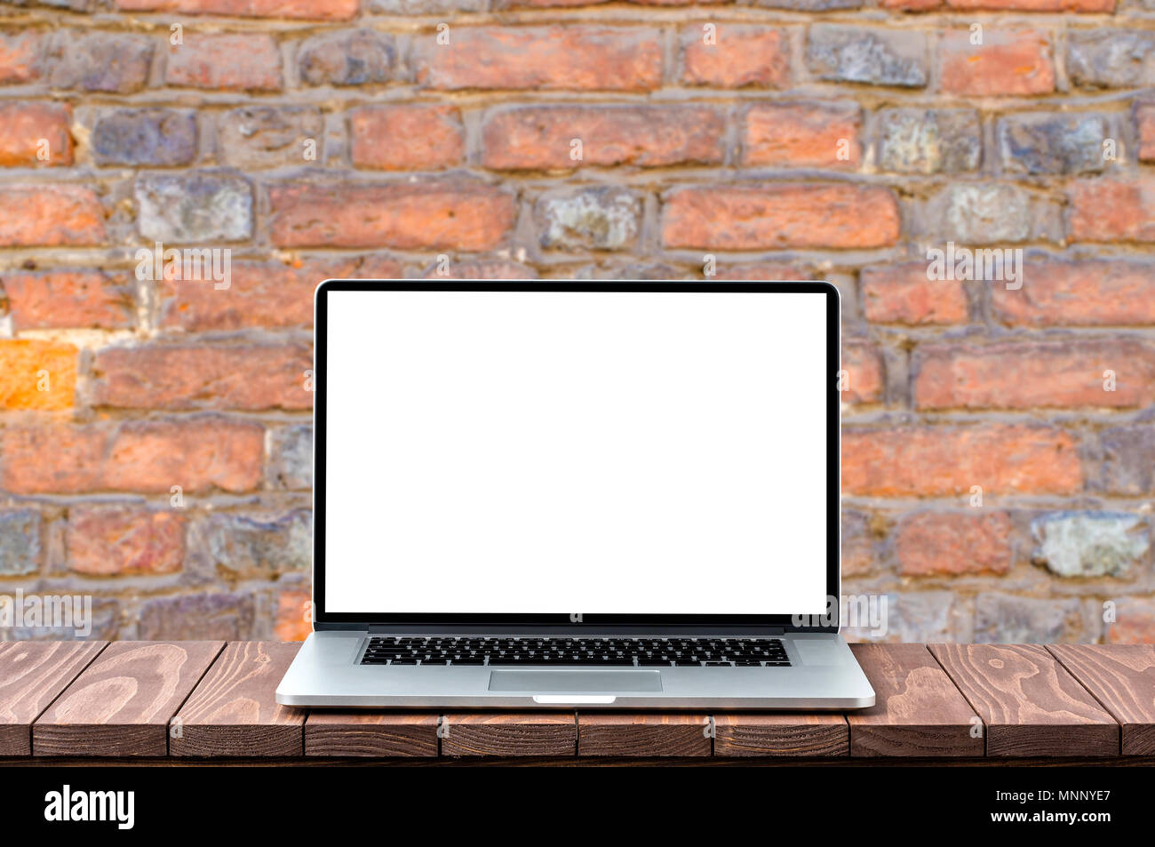 Modern laptop with empty white screen on wooden table against blurred ...
