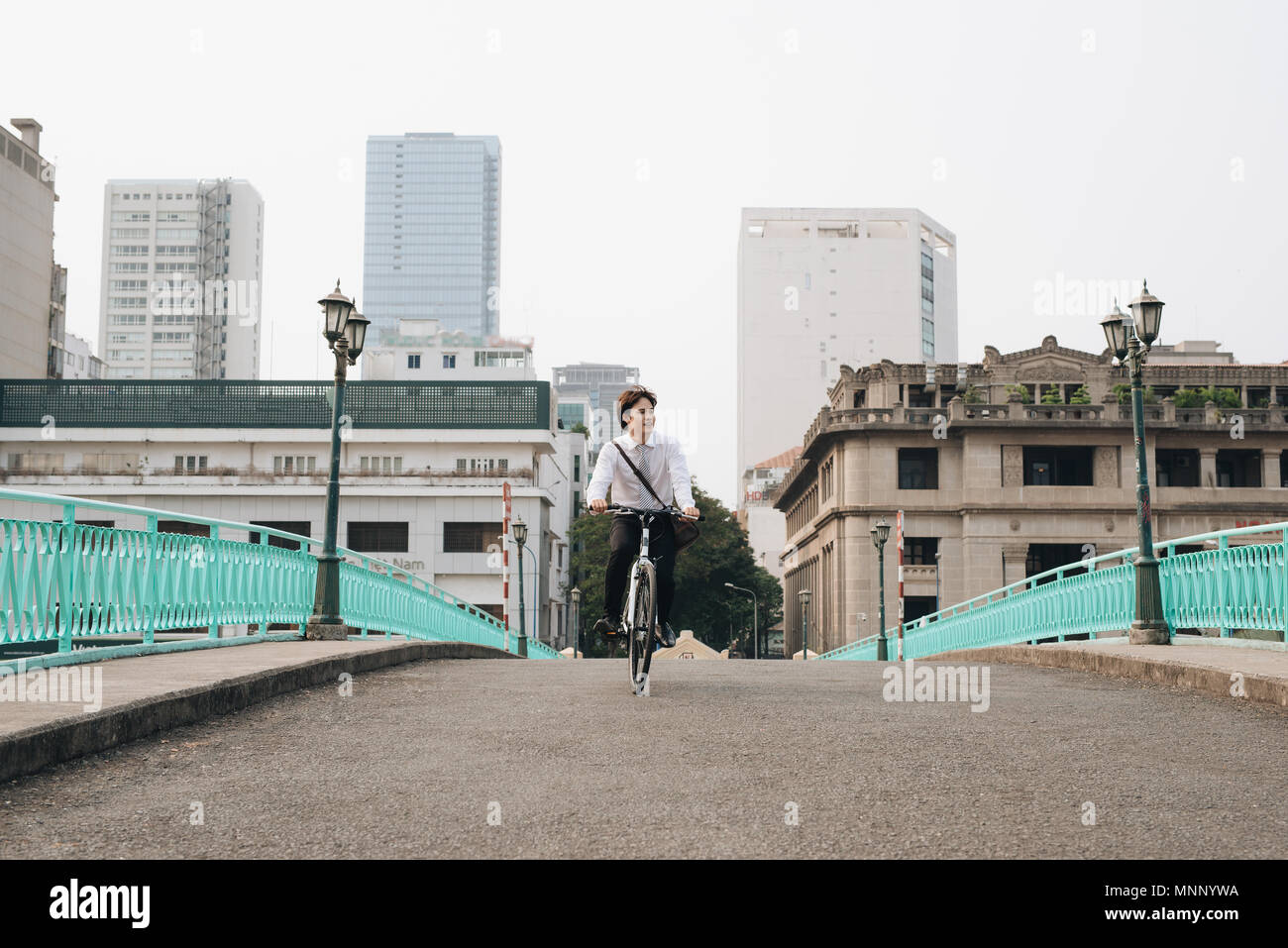Going everywhere by his bike. Side view of young businessman looking ...