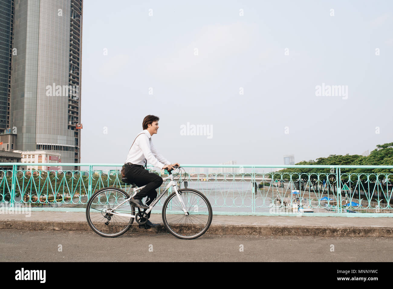 Going everywhere by his bike. Side view of young businessman looking ...
