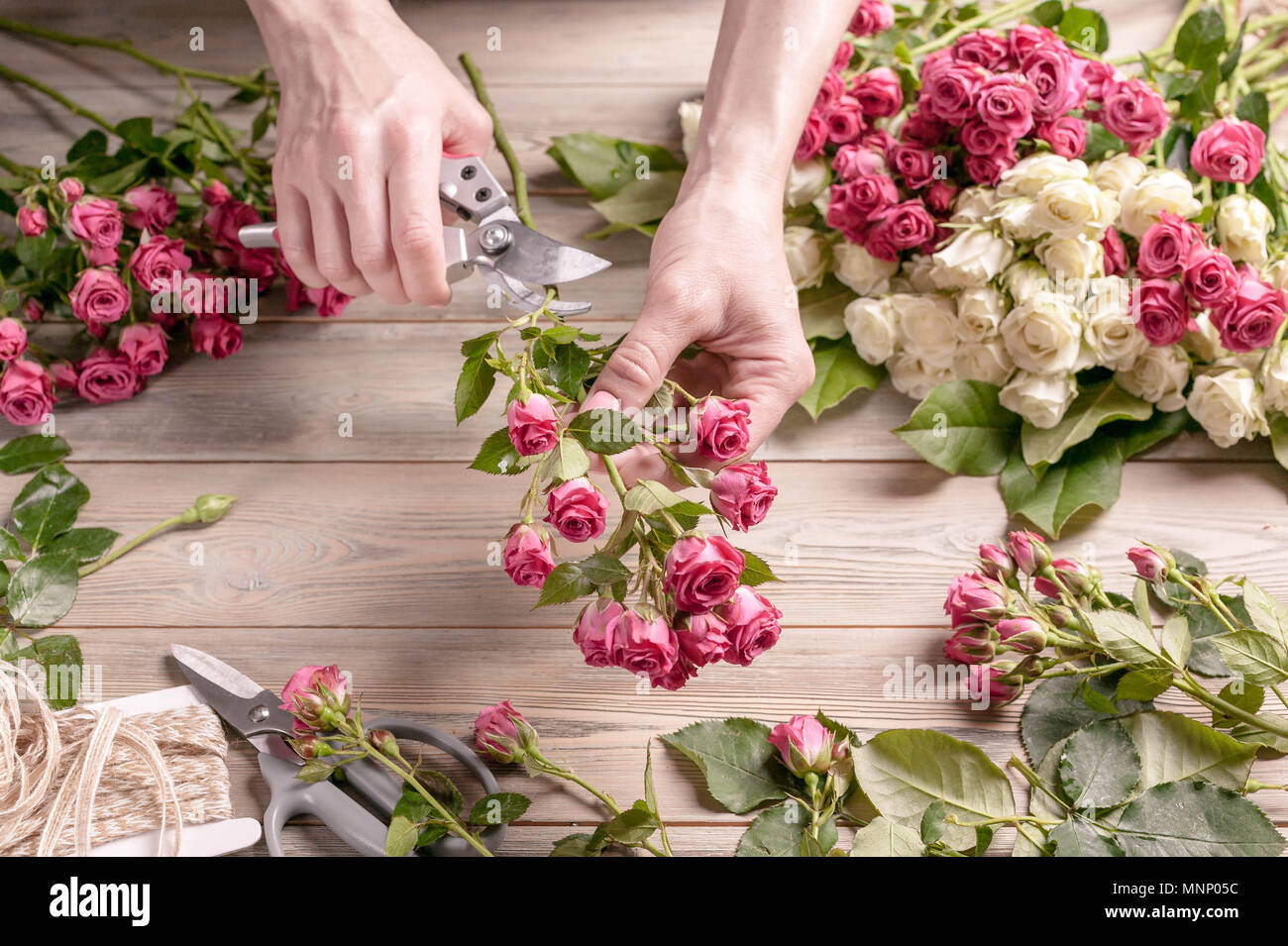Florist at work. Female hands collect a wedding bouquet of roses ...