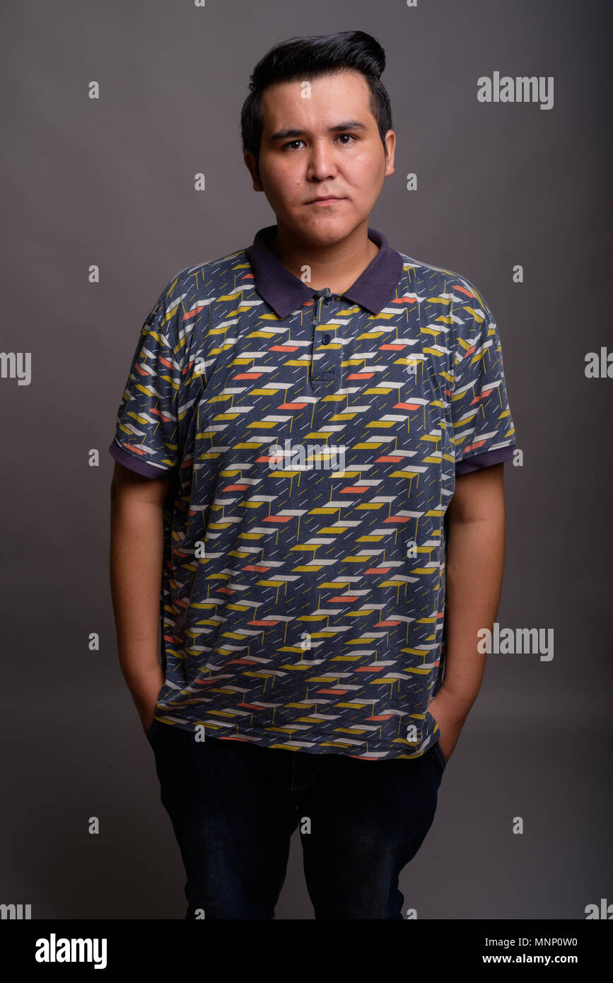 Young multi-ethnic man against gray background Stock Photo - Alamy