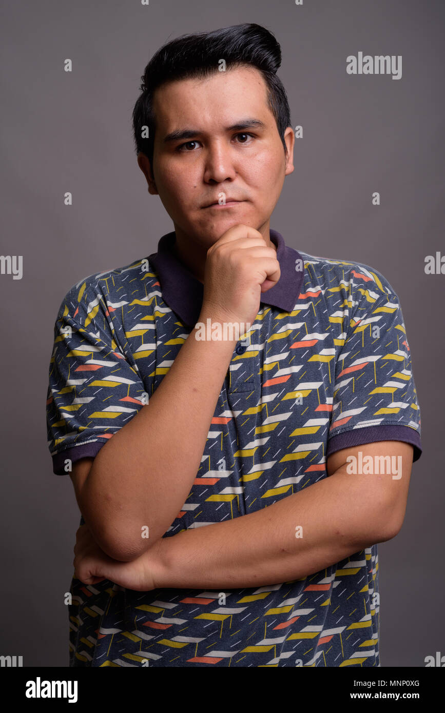 Young multi-ethnic man against gray background Stock Photo - Alamy