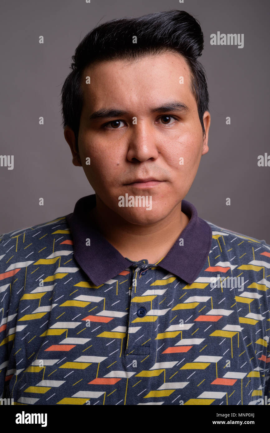 Young multi-ethnic man against gray background Stock Photo - Alamy