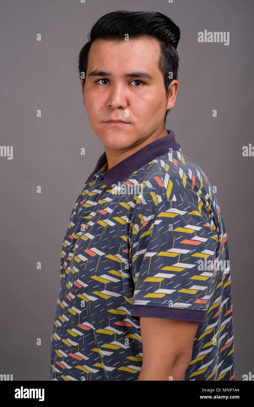 Young multi-ethnic man against gray background Stock Photo - Alamy