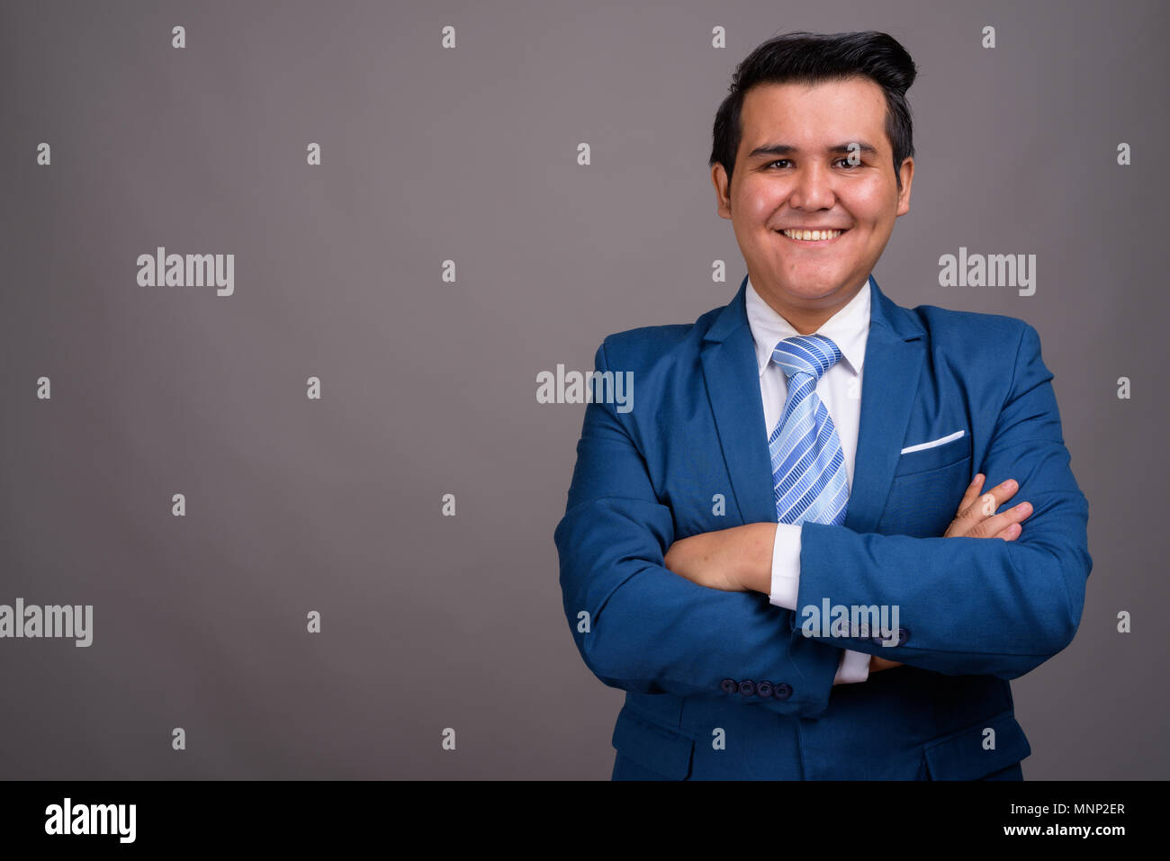 Young multi-ethnic businessman against gray background Stock Photo - Alamy