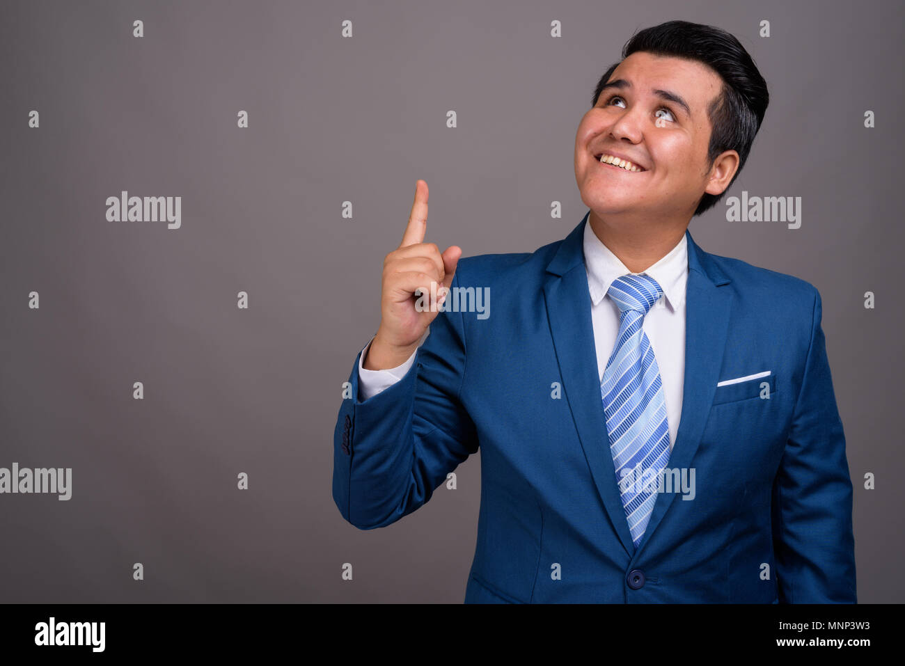 Young multi-ethnic businessman against gray background Stock Photo - Alamy