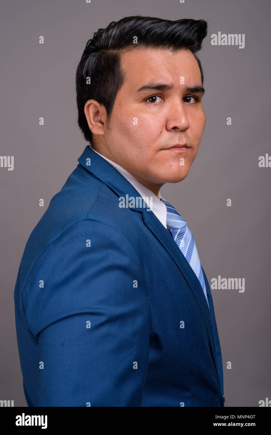 Young multi-ethnic businessman against gray background Stock Photo - Alamy