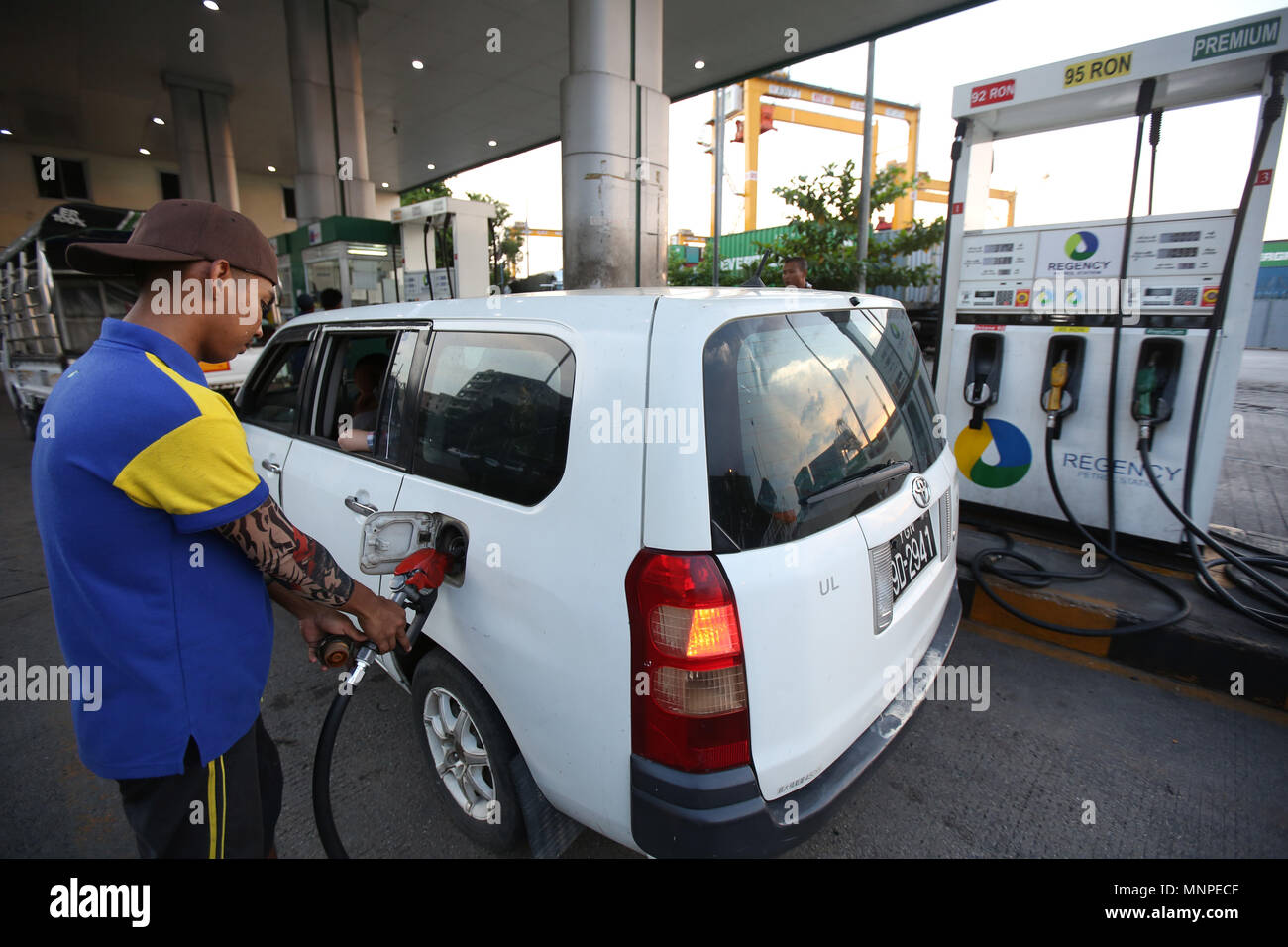 Yangon, Myanmar. 19th May, 2018. An employee fuels a car at a private ...