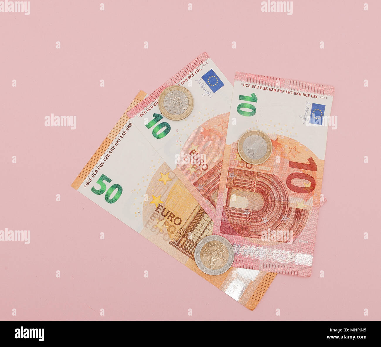 Euro money: closeup of banknotes and coins on a Pink Background ...