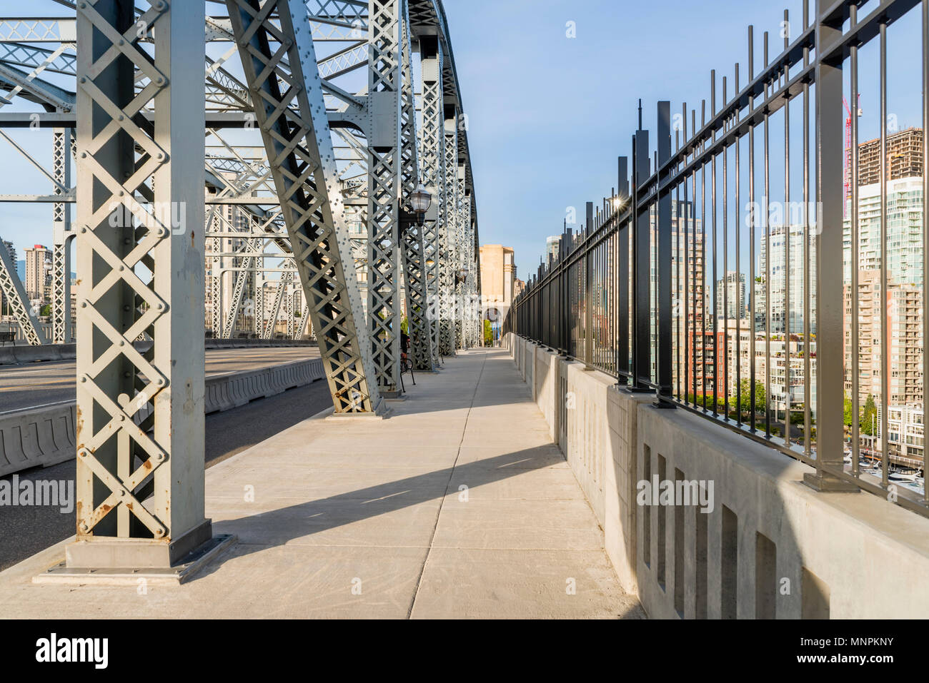 footpath on a bridge with metal supports in a modern city with new ...