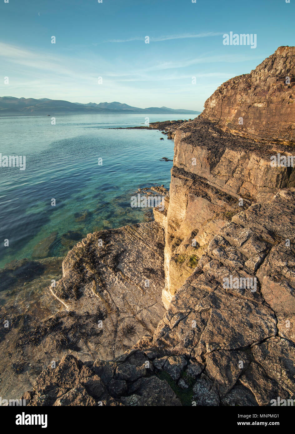 View from eroded limestone cliff over Menai Strait and Snowdonia hills ...