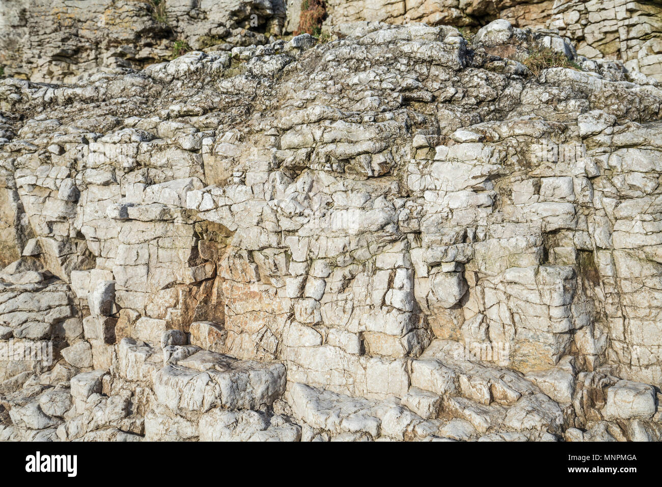 Surface of heavilly eroded marine cliff rock in brown-grey colours ...