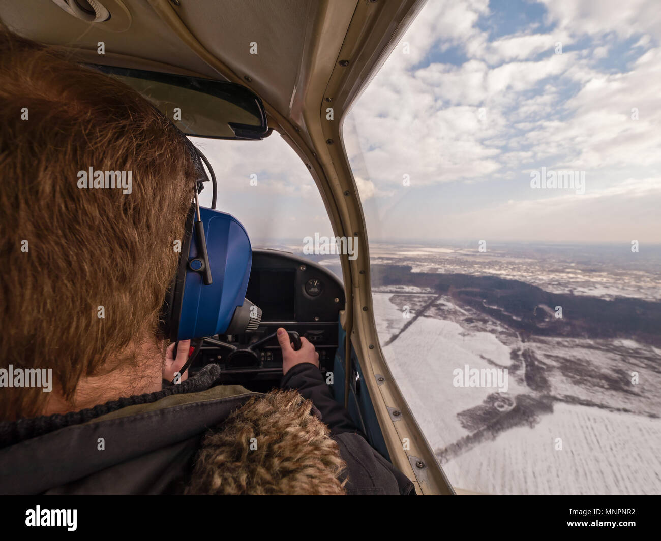 Rear view of pilot and copilot operating controls of corporate jet ...