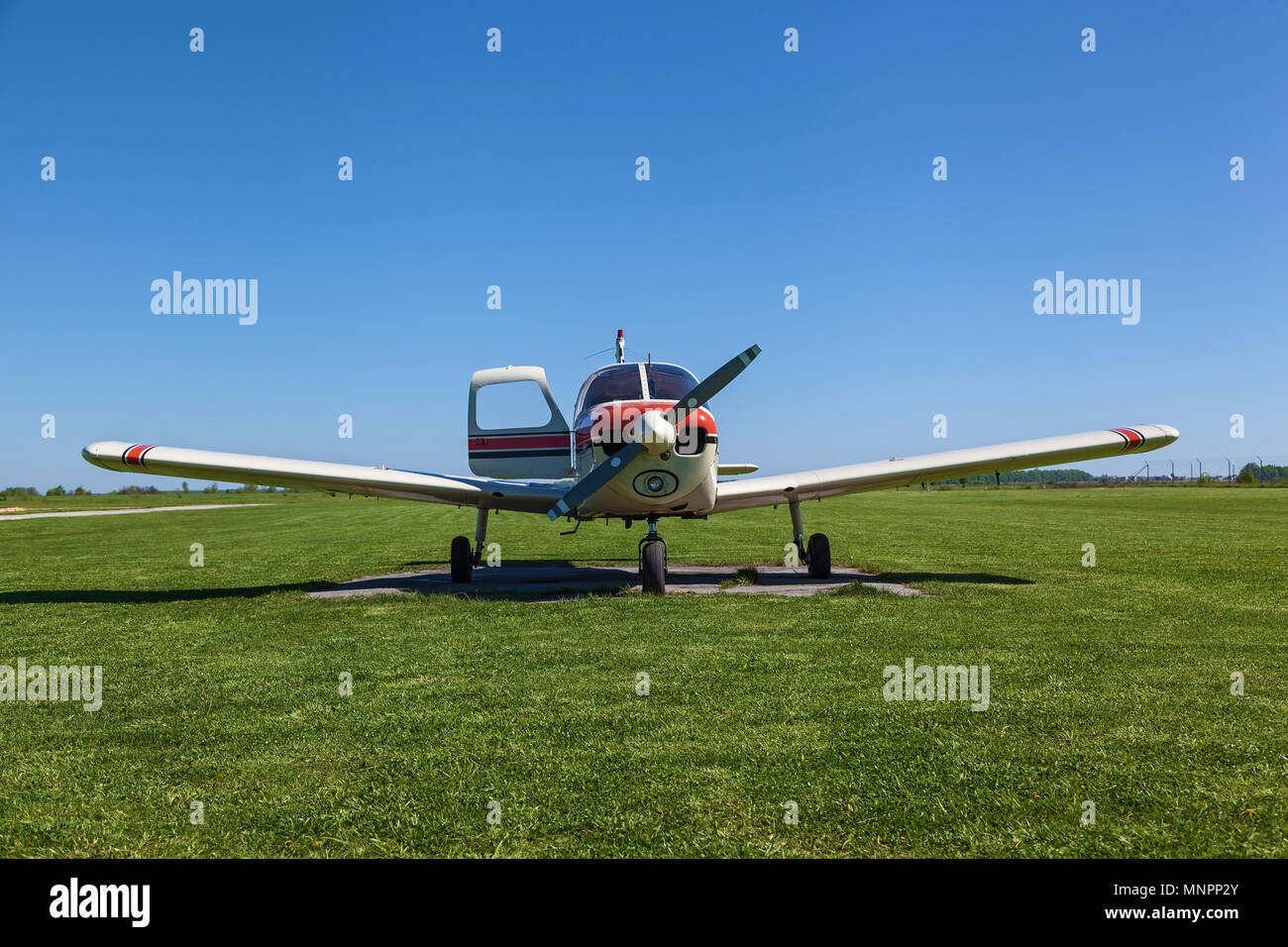 The plane Piper Cherokee stands on the green grass on a sunny day. A ...