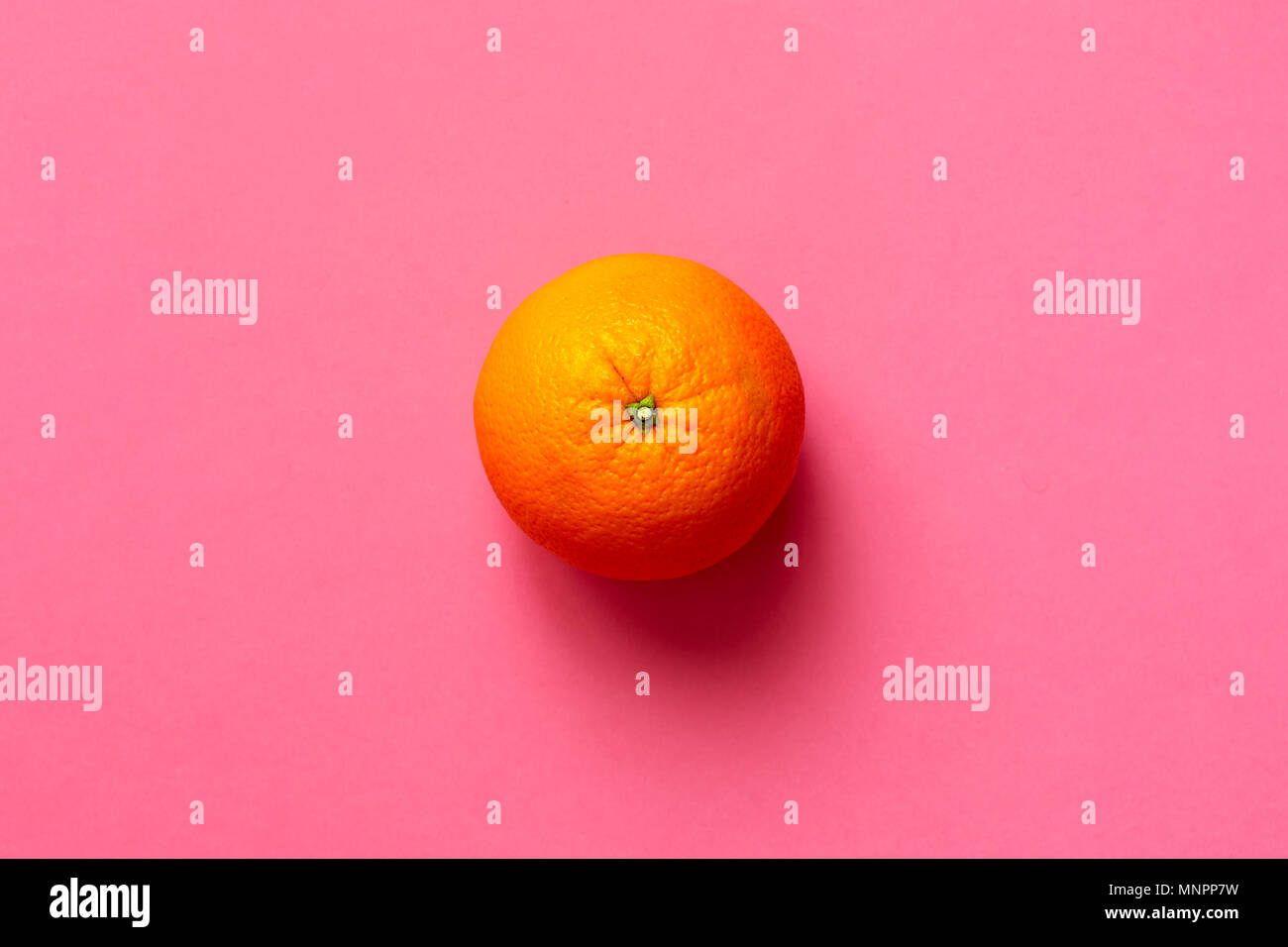 Fresh orange fruit isolated on fuscia background viewed from above ...