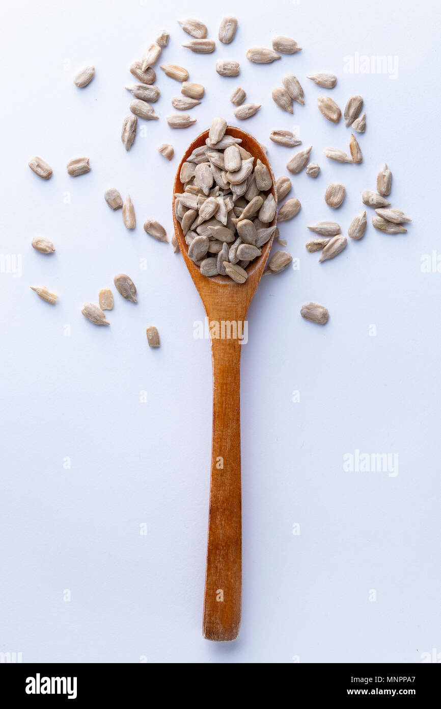 Flat lay of wooden spoon filled with small seeds of sunflower lying on ...