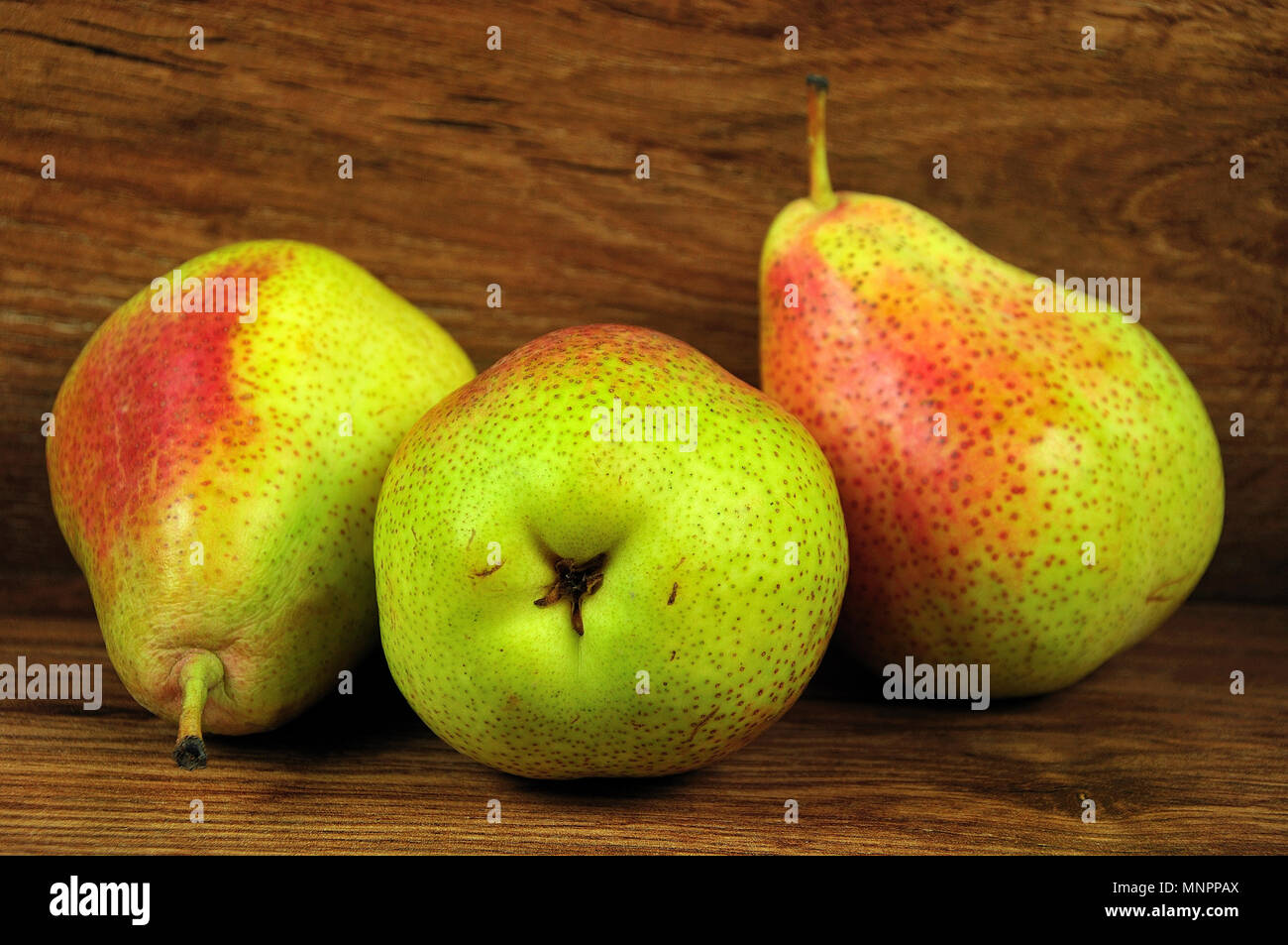 pears with red and yellow skin lying on wooden worktop in a kitchen ...