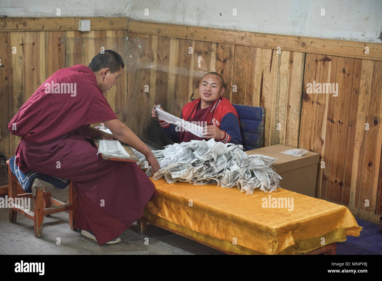 Monks making handmade paper scriptures and woodblock prints inside the ...