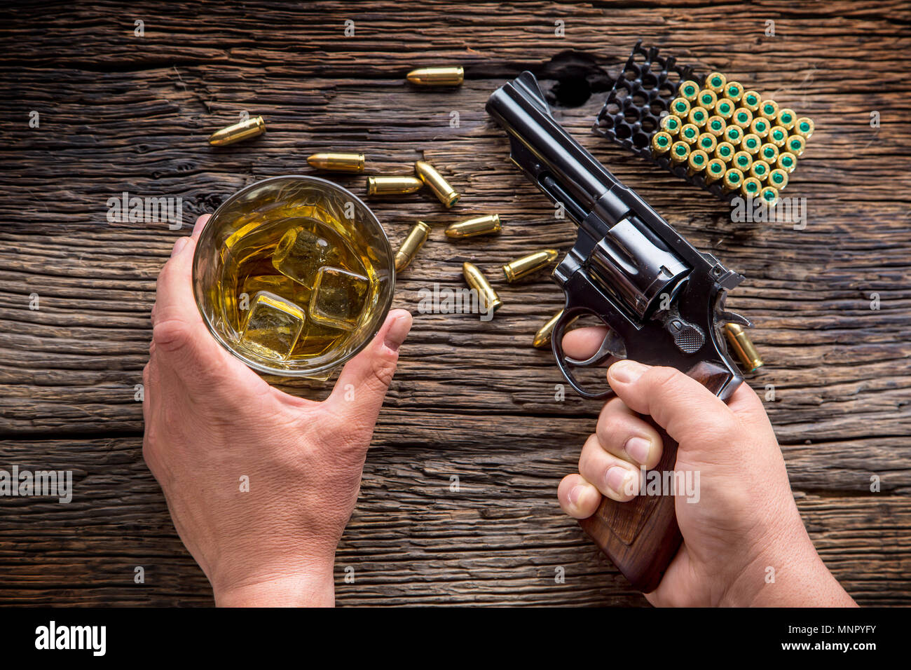 Man hands holding gun and alcohol glass on the table Stock Photo - Alamy
