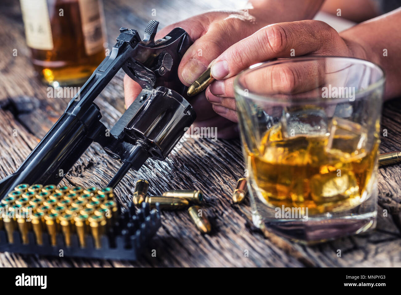 Man hands holding gun and alcohol glass on the table Stock Photo - Alamy