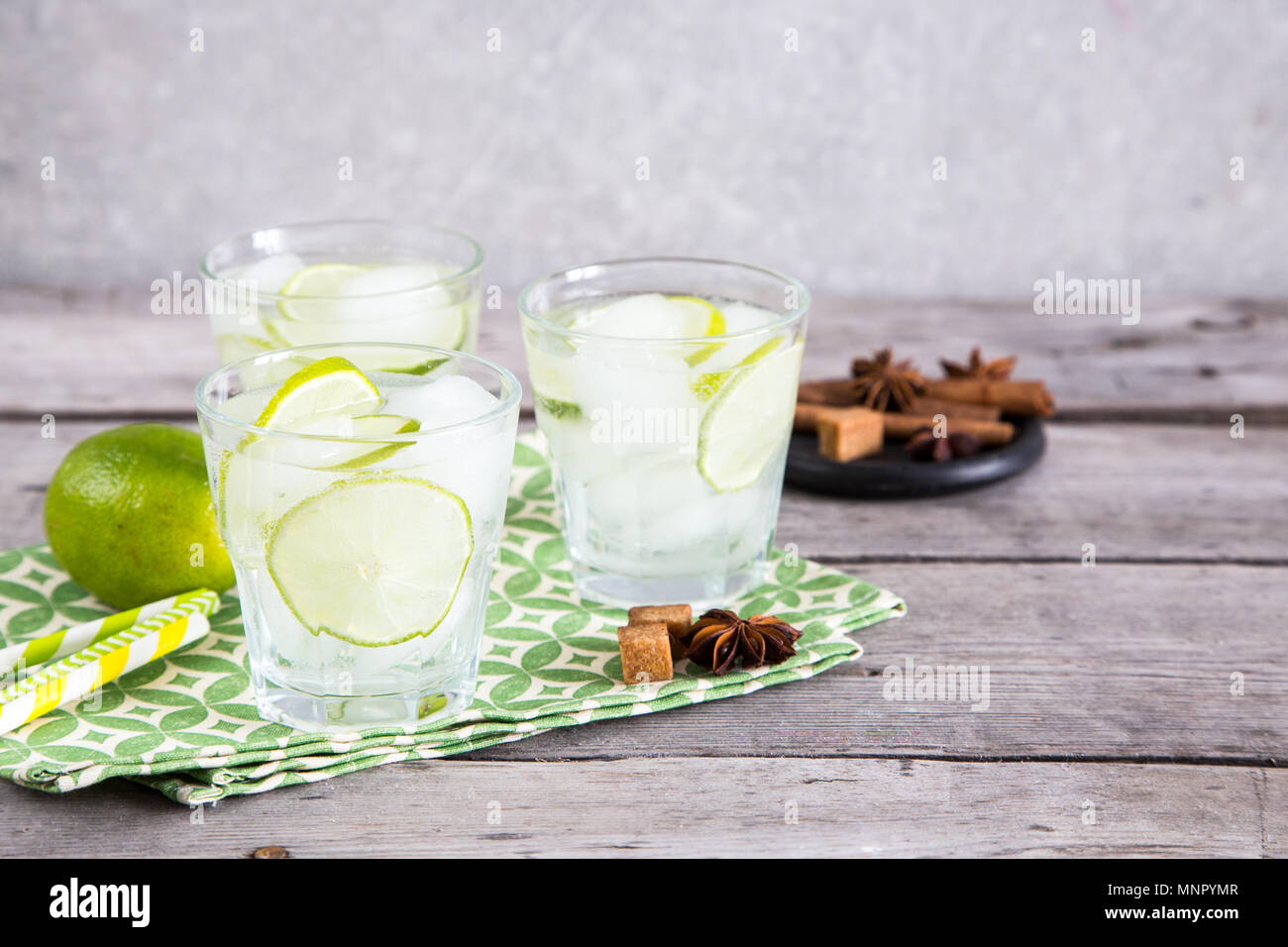 homemade lemonade with lime, anise, cinnamon and ice on a wooden ...