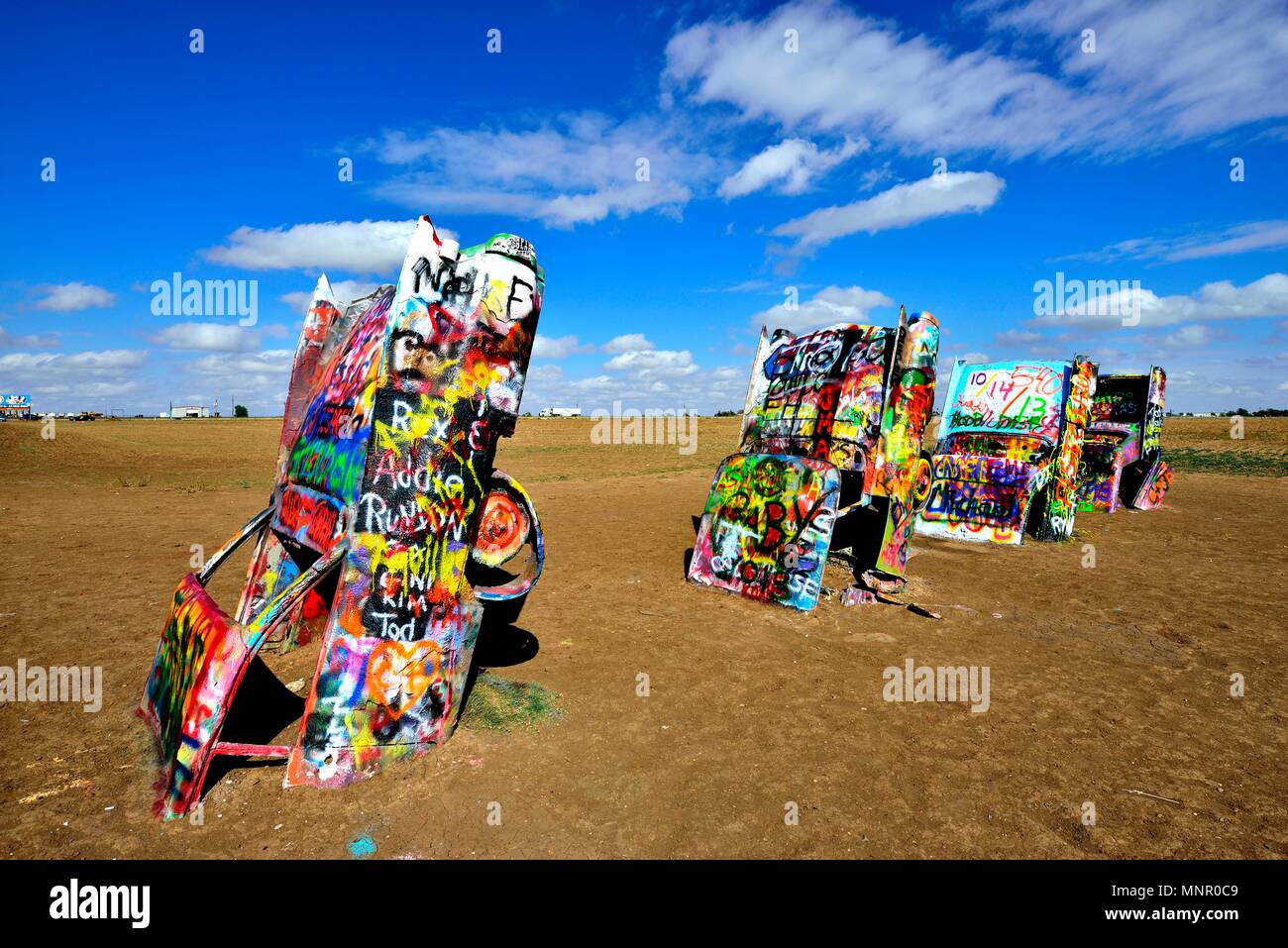 Painted Cadillacs rammed into the ground, public art installation ...