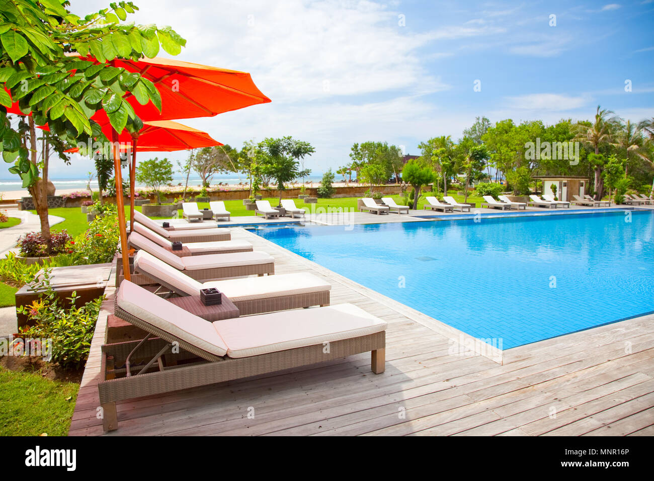 Clear blue water in swimming pool and tropical beach behind, Indonesia ...