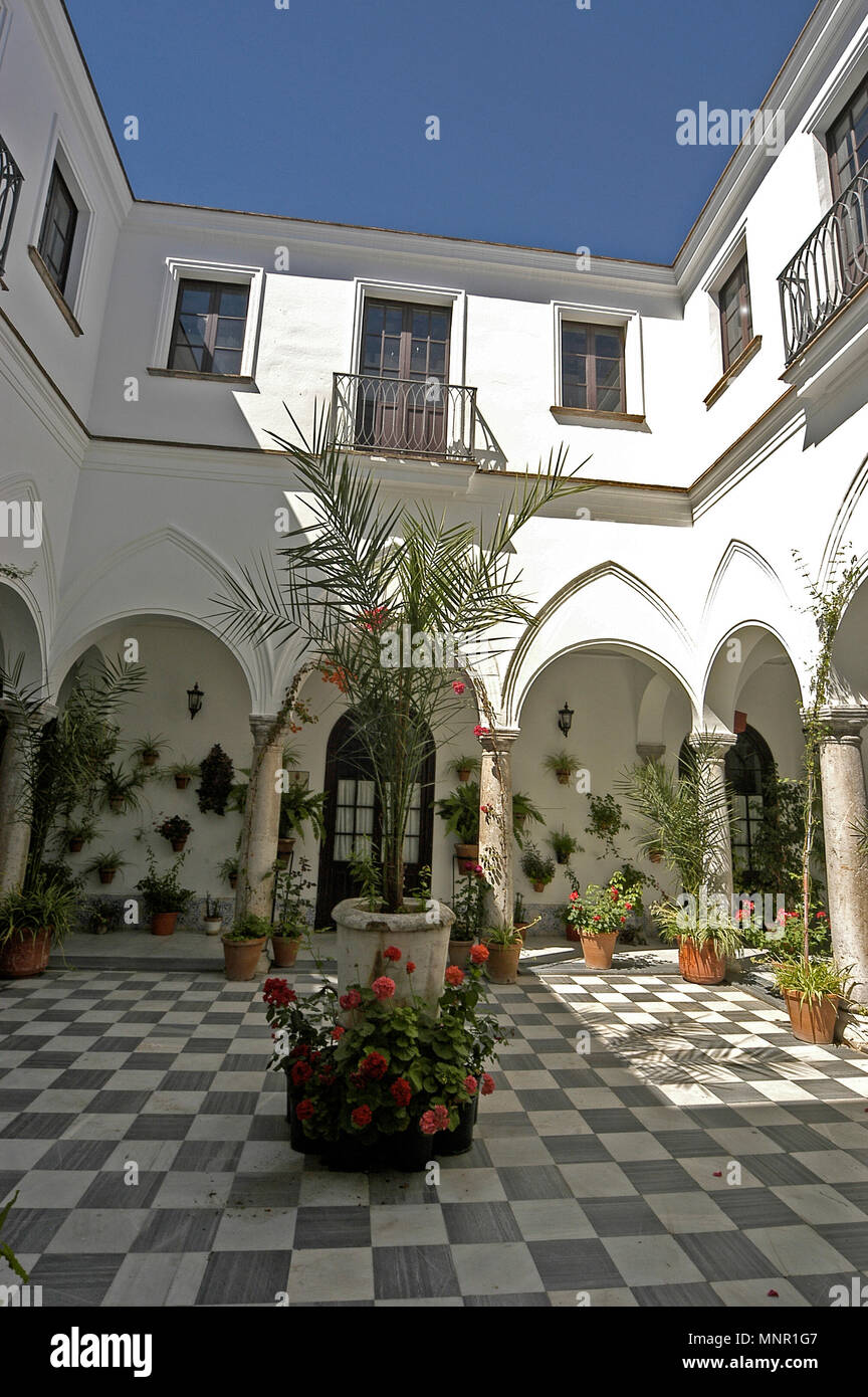 A large Spanish inner courtyard with Moorish architectural arches in a ...