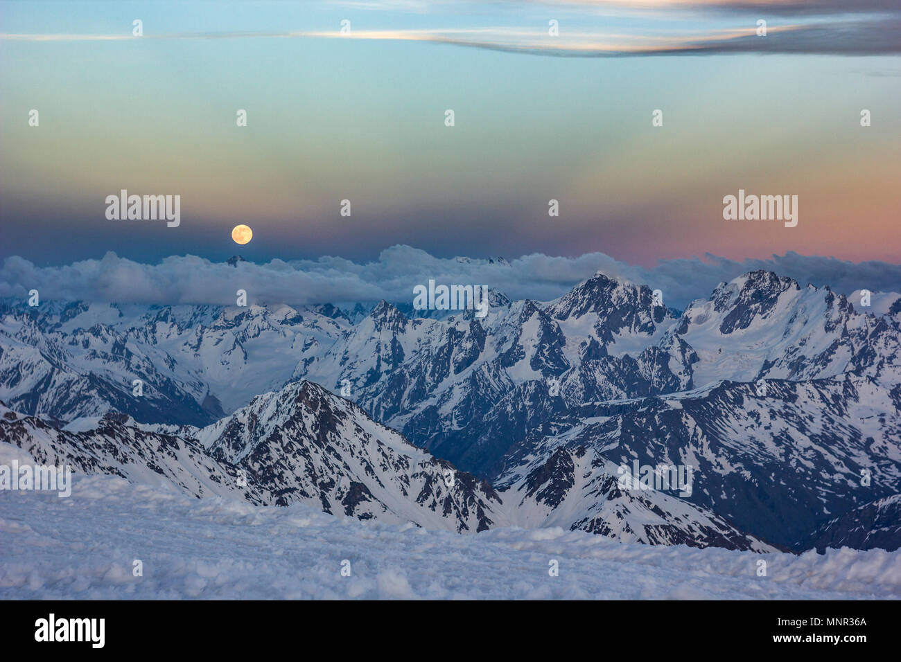 snowy Caucasus mountains at sunset with moonrising and Anticrepuscular ...