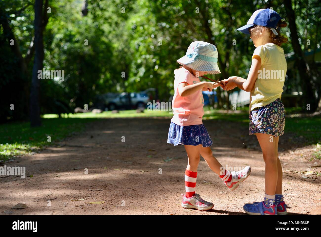 Two children play together in natural light outside hi-res stock ...