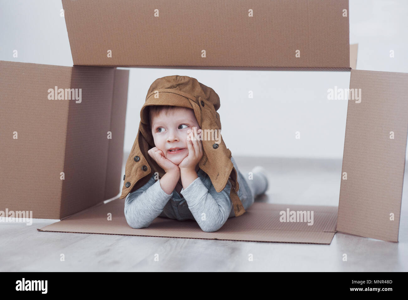 Child preschooler boy playing inside paper box. Childhood, repairs and ...