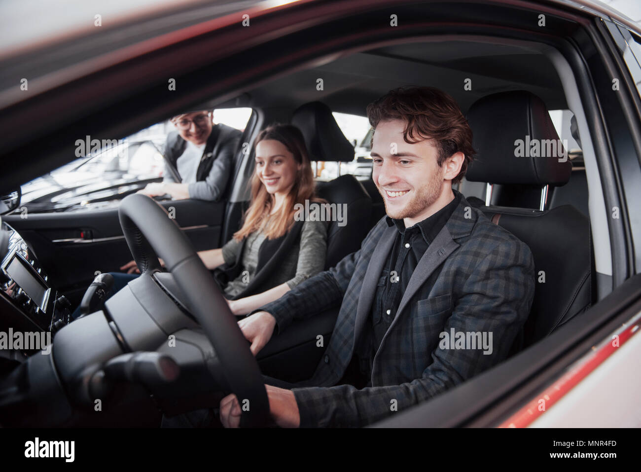 Making their decision. Beautiful loving couple sitting in a new car ...