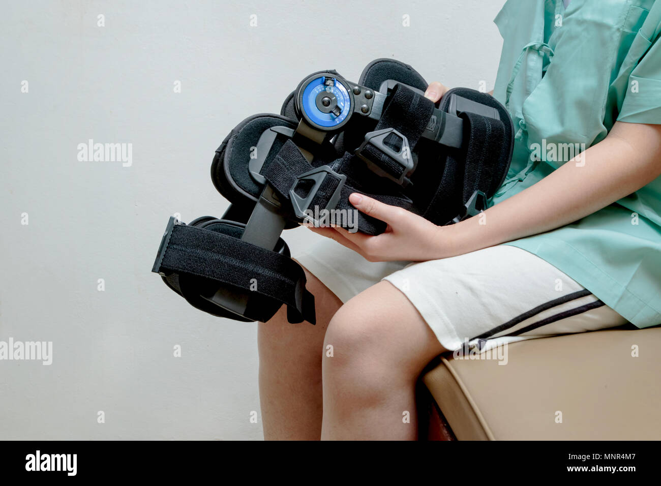 Injured woman with leg splint sitting on bed in rehab center Stock ...
