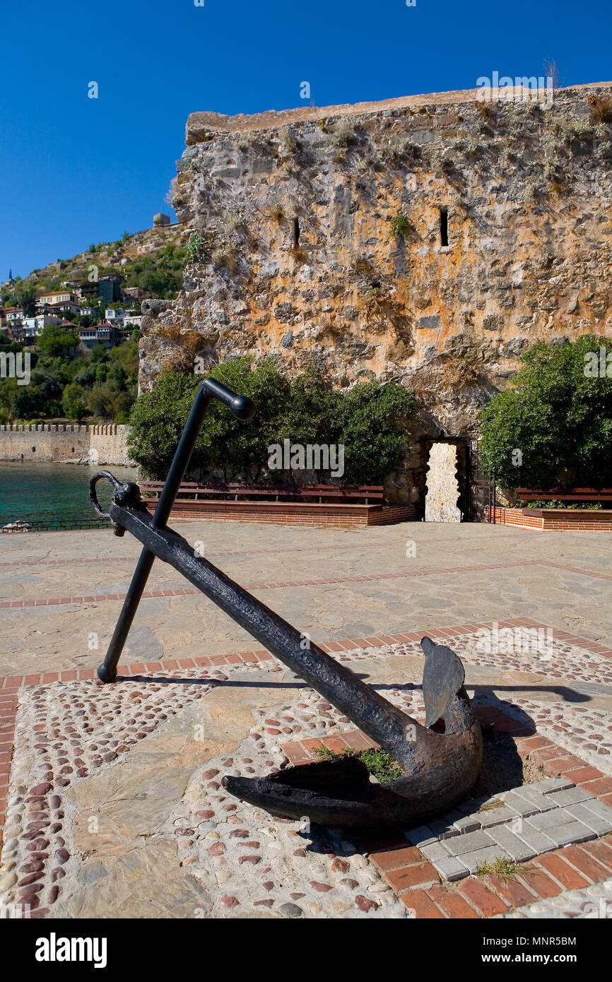 A large metal anchor in the background of the fortress of Alanya ...